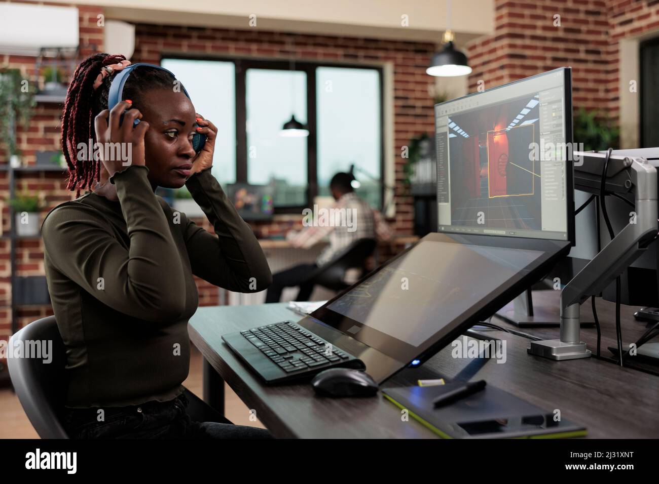 Creative game developer following CGI render on computer screen while ...