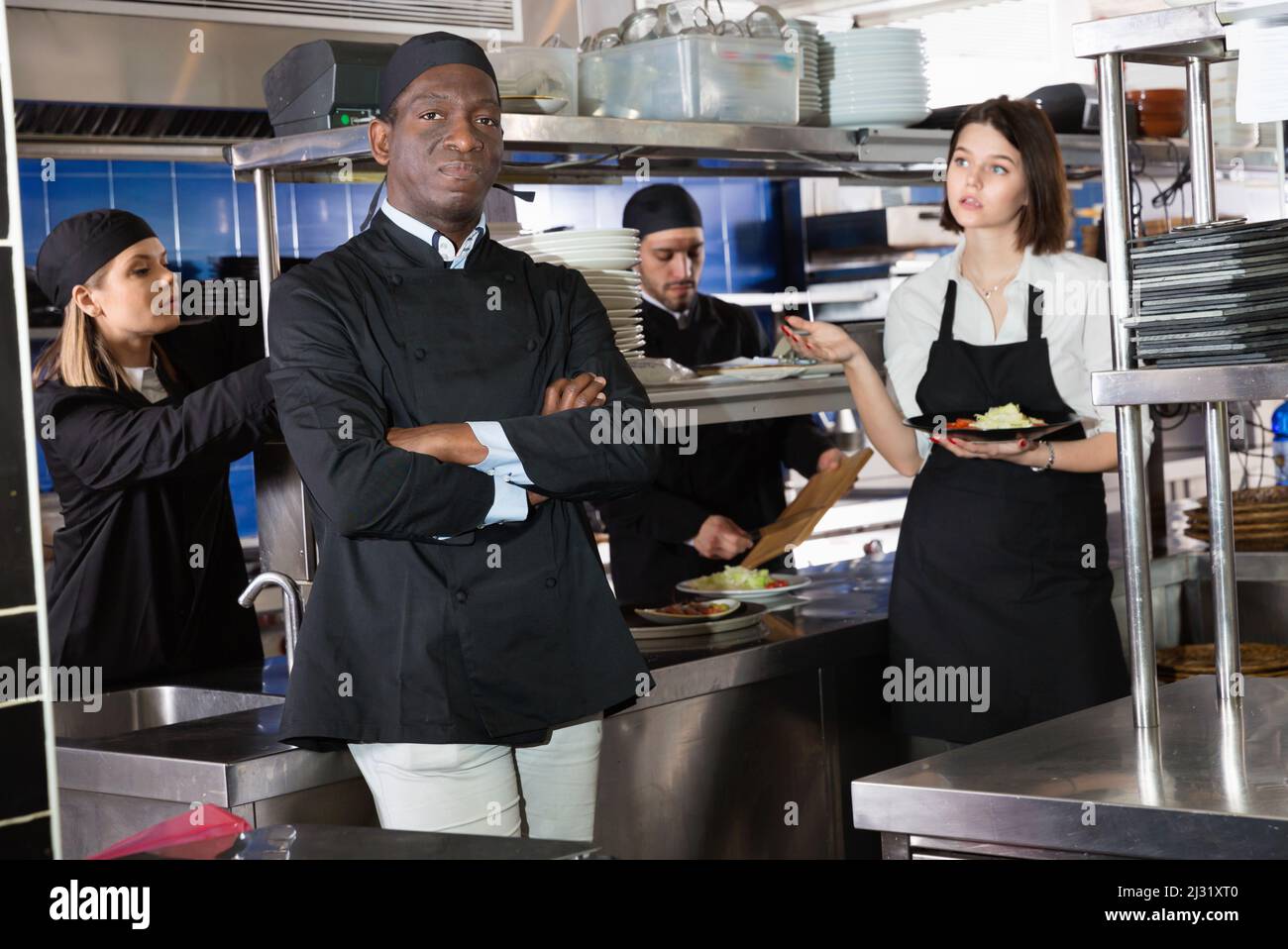 Smiling chef cook is posing on kitchen in restaurant Stock Photo - Alamy