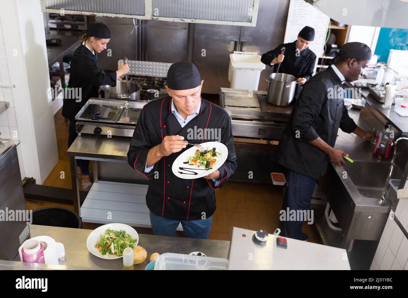 Chef with team preparing food Stock Photo - Alamy