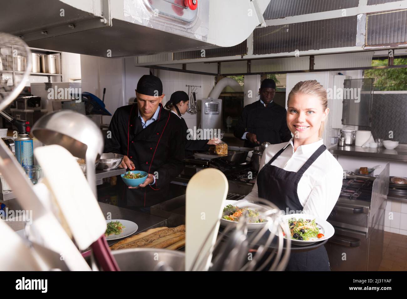 Waitress in restaurant kitchen with ordered meals Stock Photo - Alamy