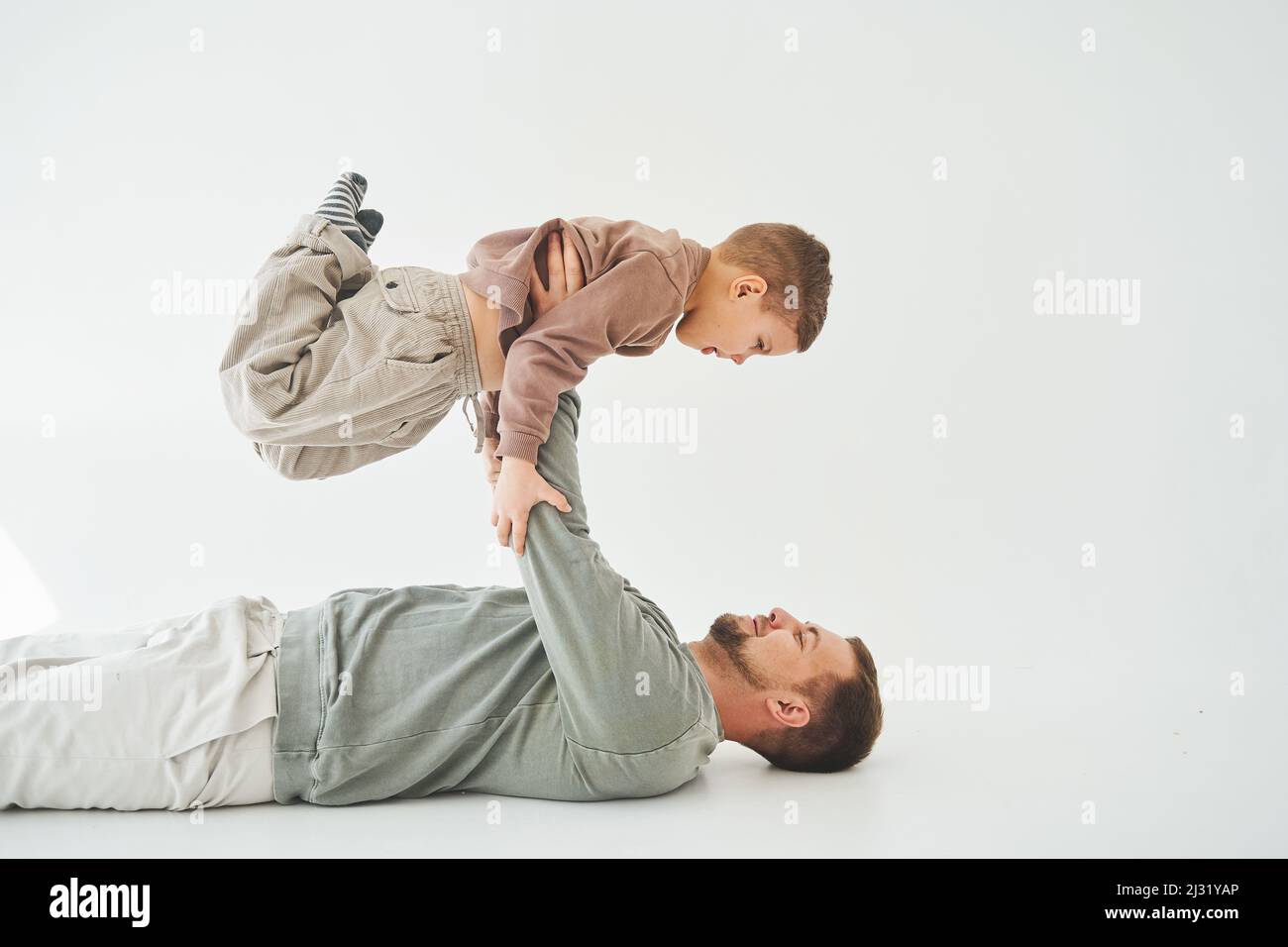 Paternity lifestyle. Father lifting child on white background. Dad and ...