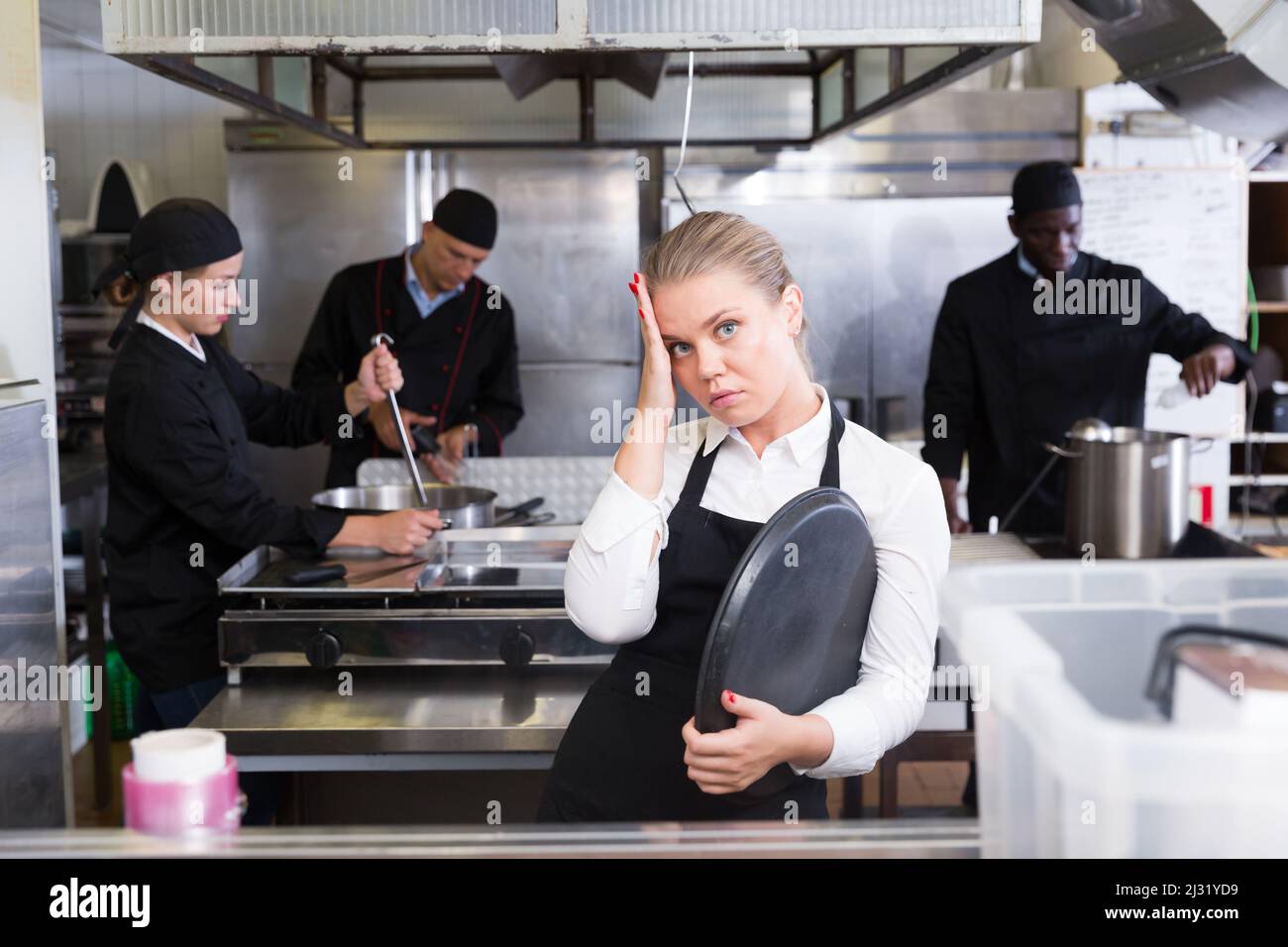 Upset waitress in kitchen of restaurant Stock Photo - Alamy