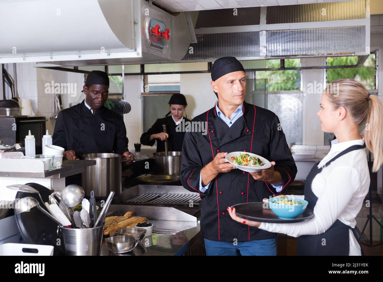 Chef checking dishes in kitchen Stock Photo - Alamy