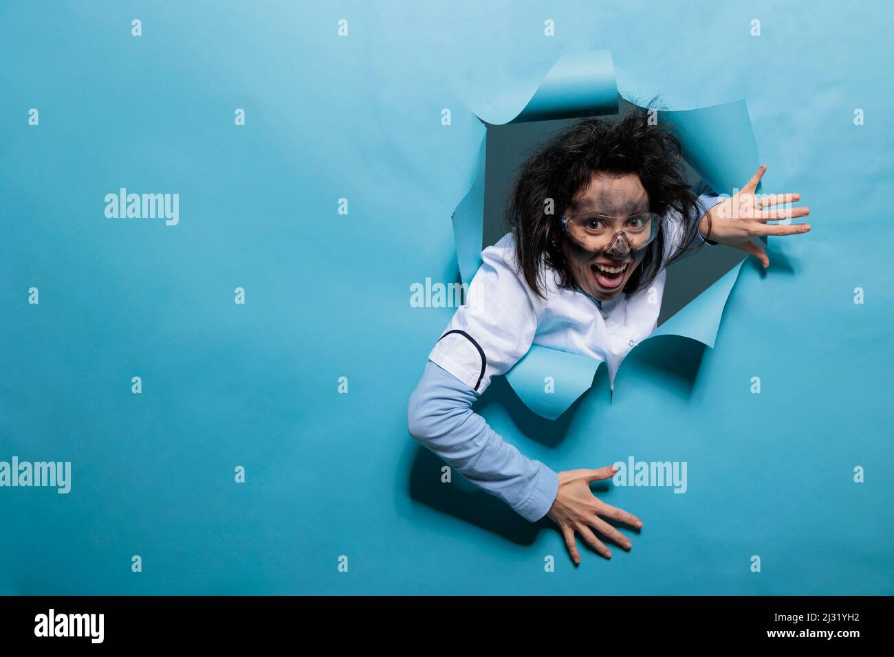 Foolish humorous scientist with comic expression on blue background ...