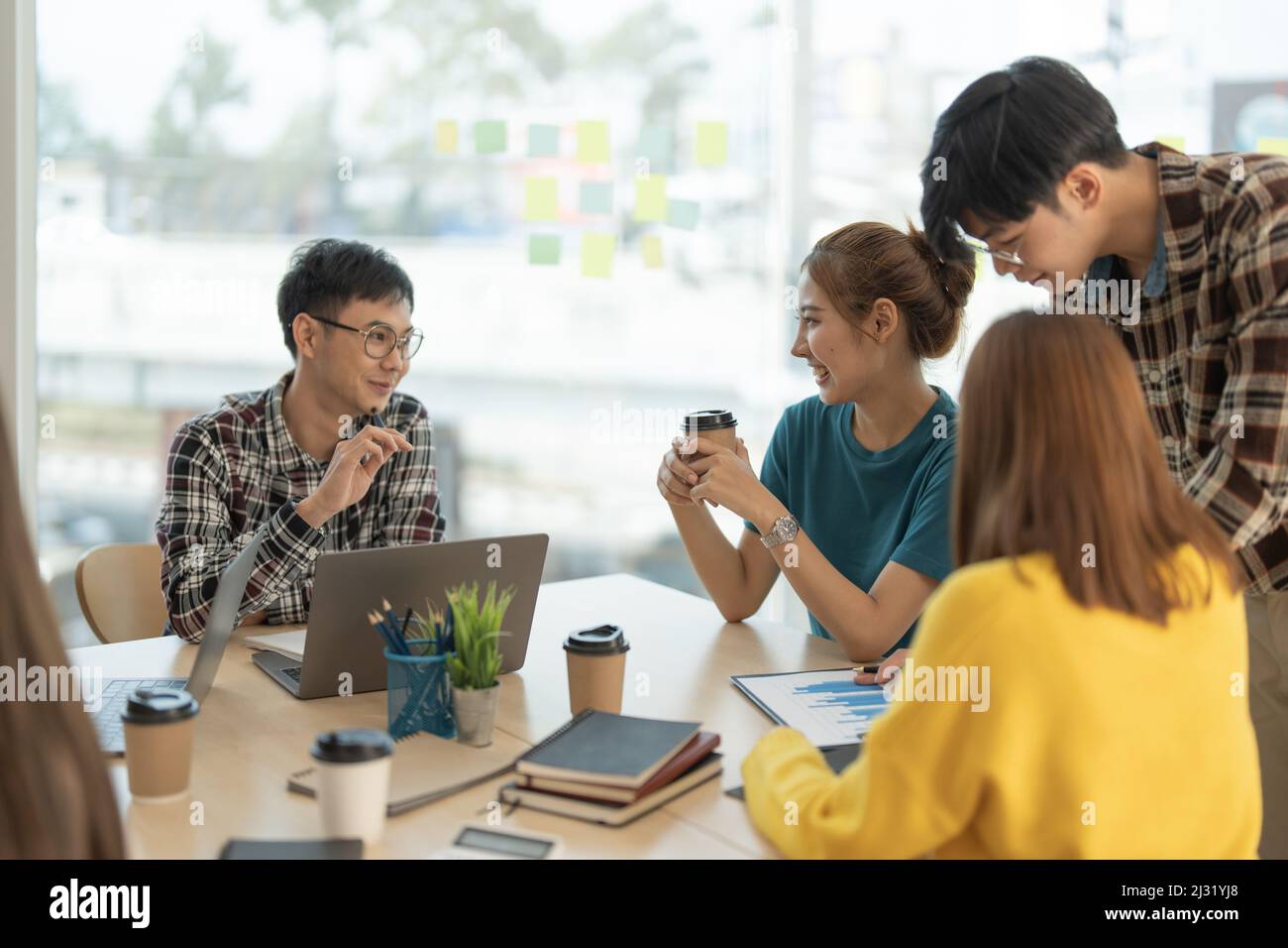 Group of asian business discussing project on laptop colleague, working ...