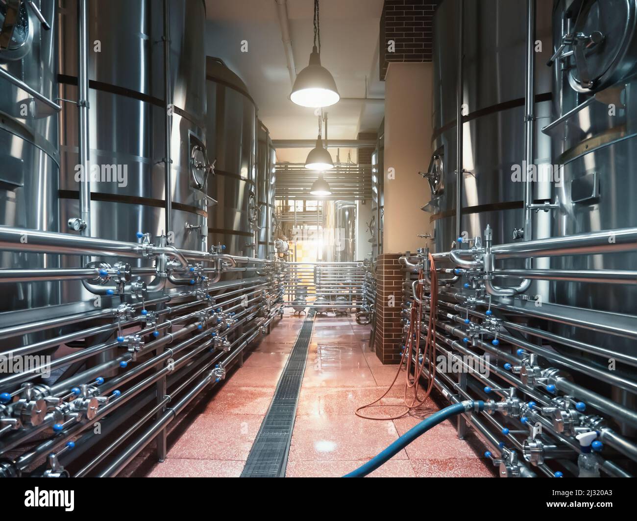 Beer tanks with many steel pipes in craft brewery Stock Photo - Alamy