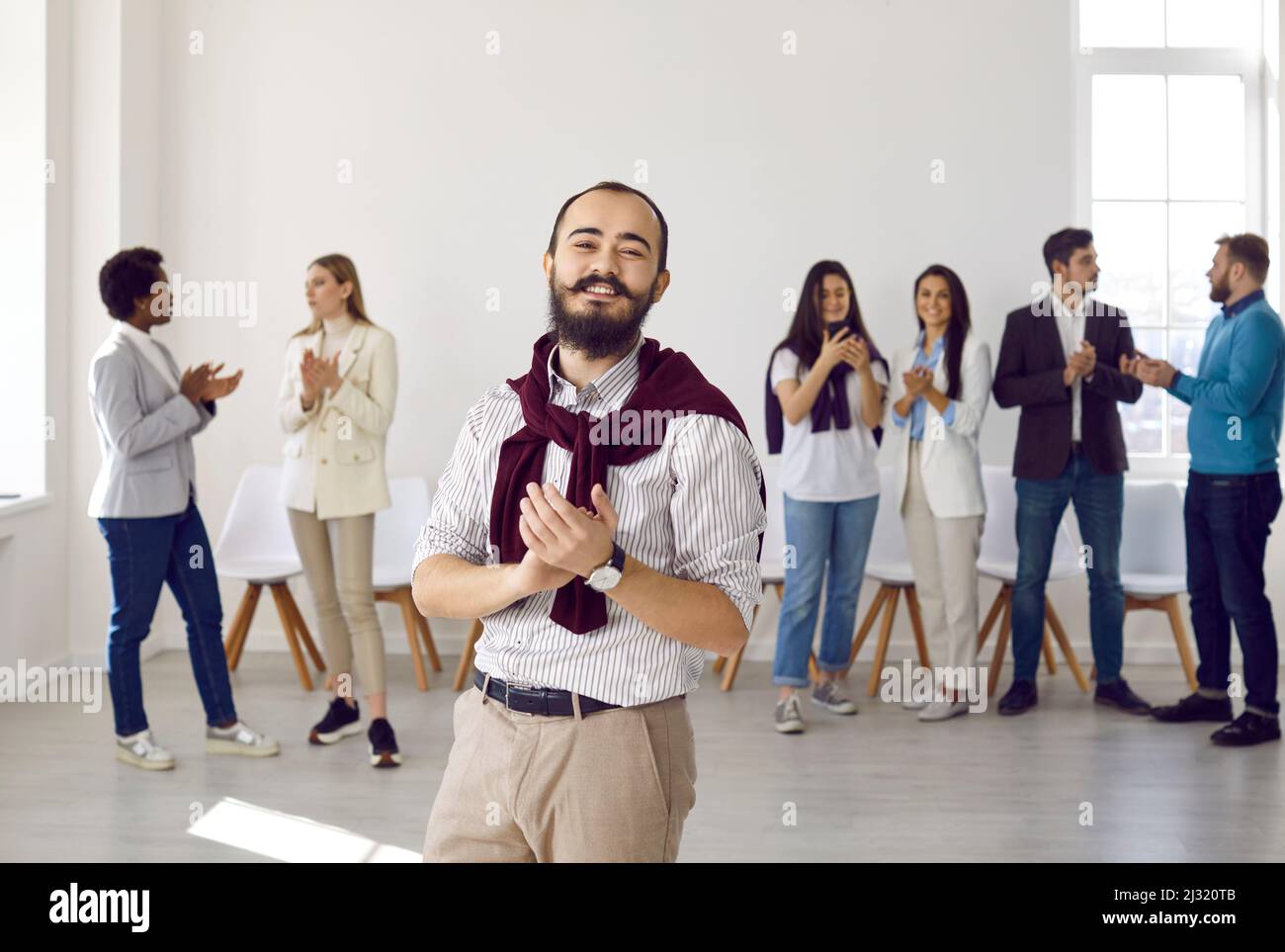 Portrait of happy successful business team leader standing in office an ...