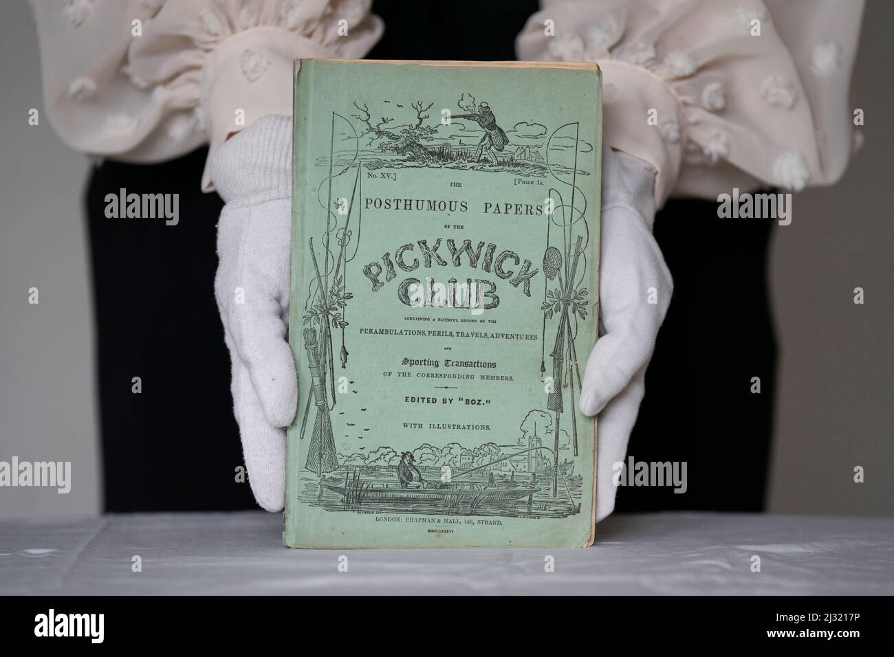 Curator Emily Dunbar holds an original monthly part of The Pickwick ...