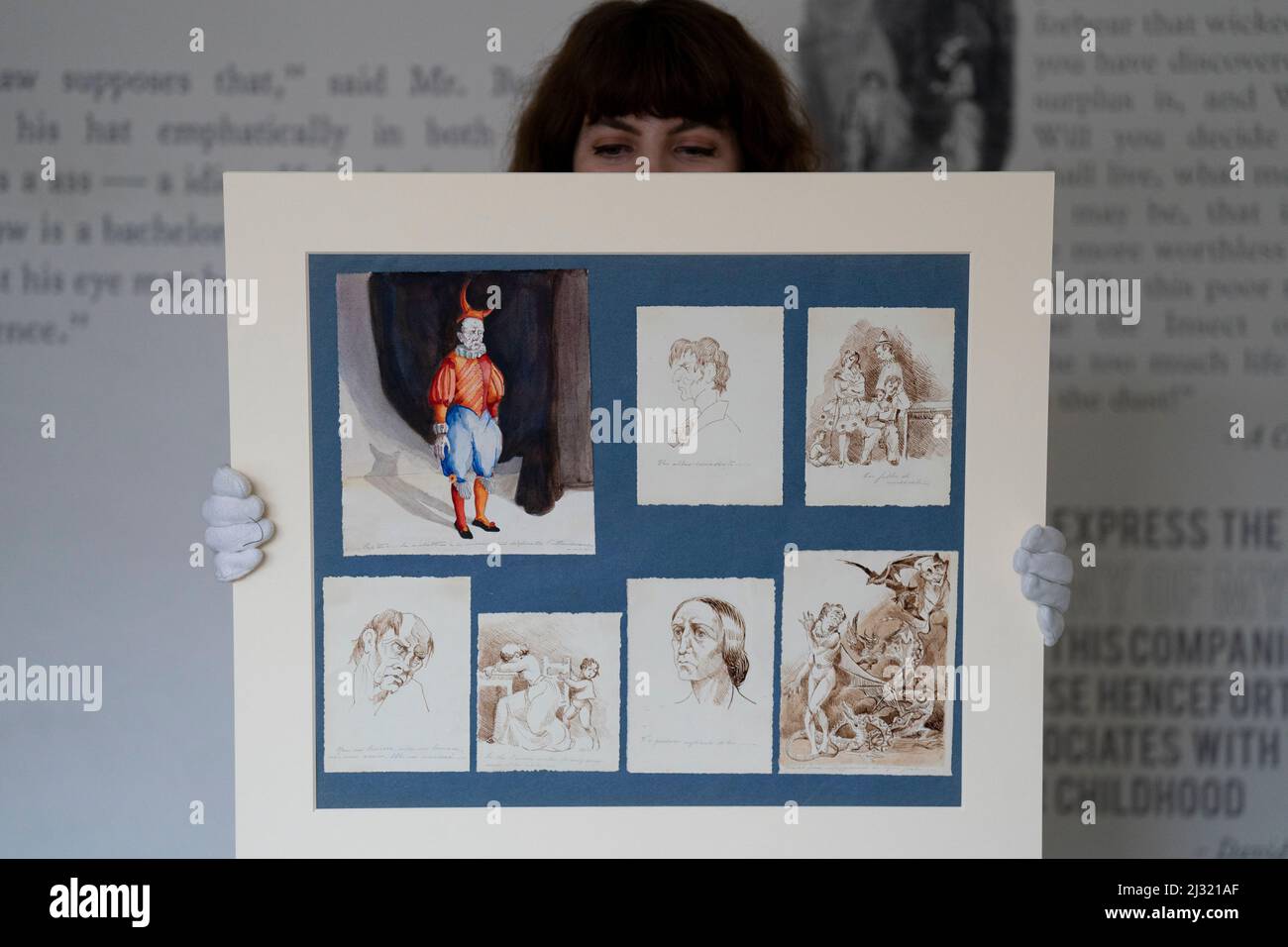 Curator Emily Dunbar holds a spread of unpublished Pickwick ...