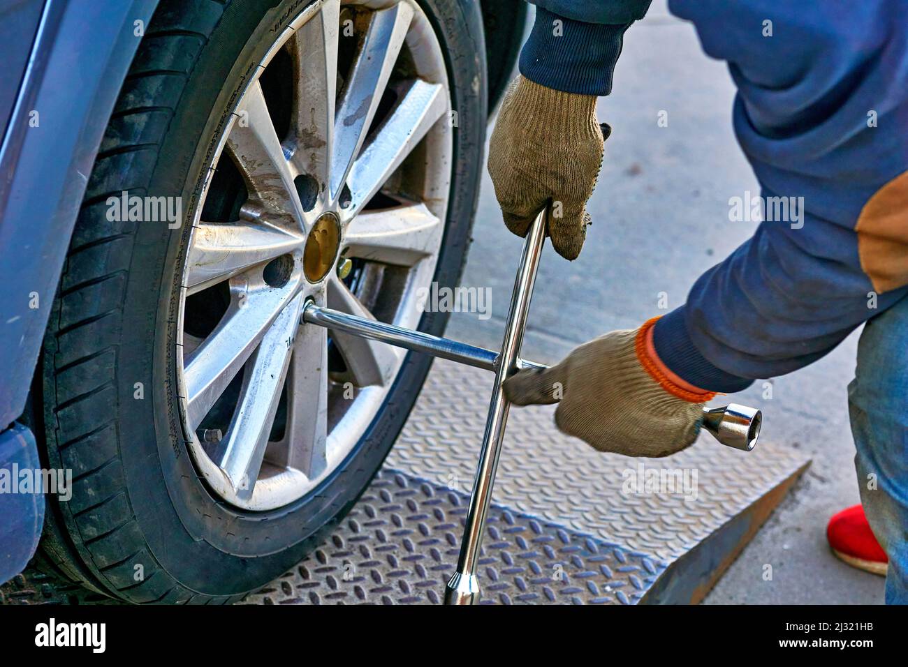 Service tire fitting. Workshop worker removing a wheel from a car Stock ...