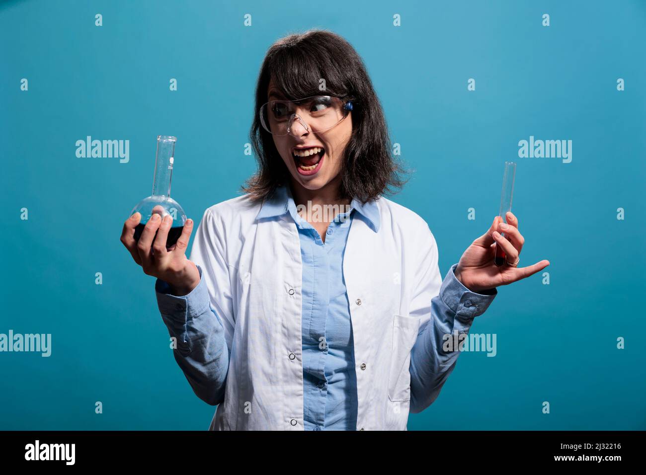 Creepy looking biochemistry specialist holding glass vials filled with ...