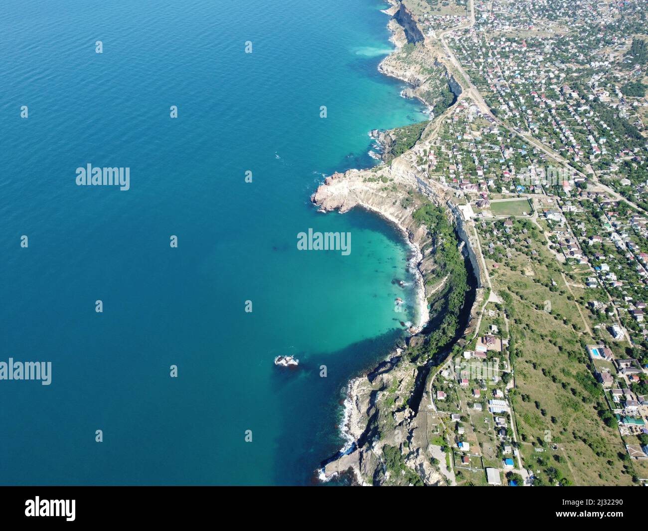 Aerial view from above on calm azure sea and volcanic rocky shores ...