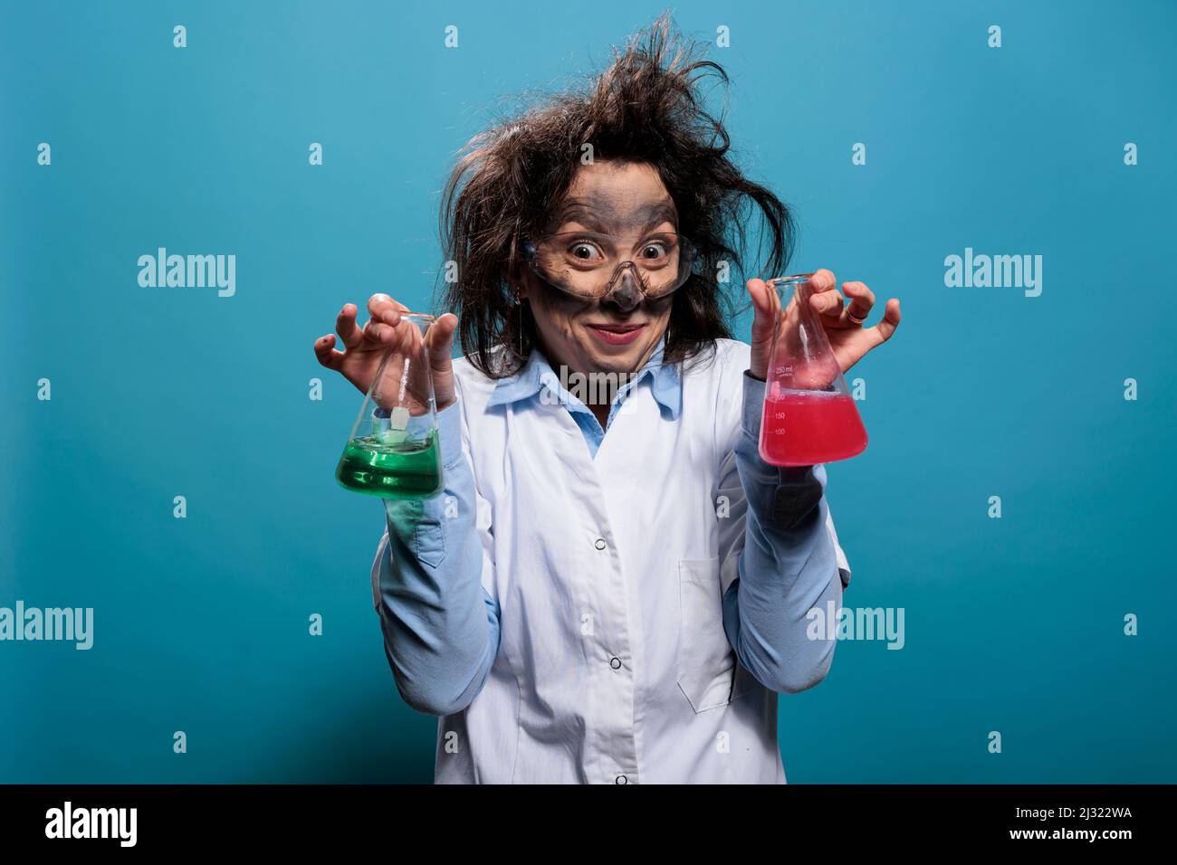 Mad scientist with dirty face and messy hair having beakers filled with ...