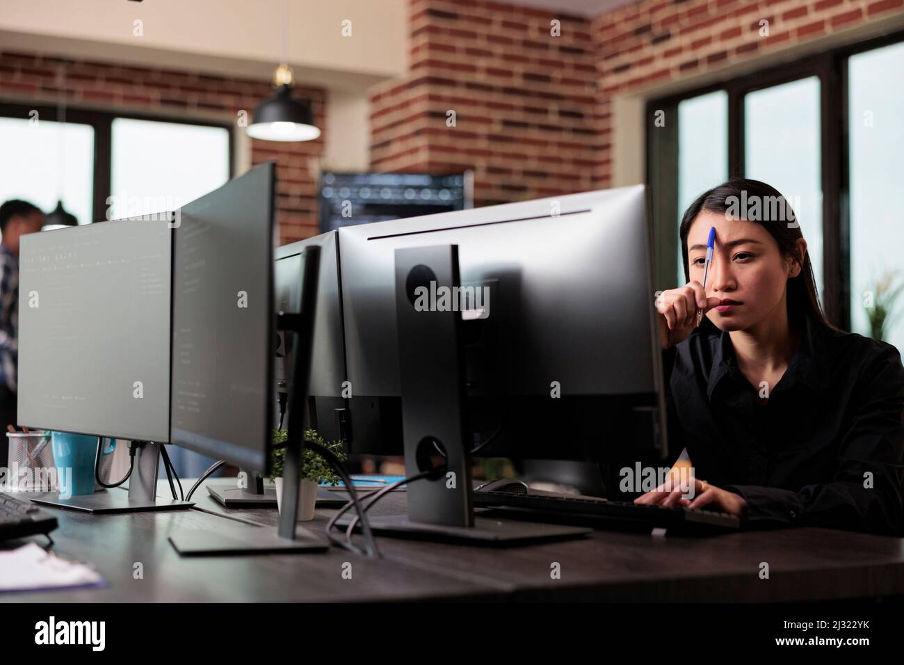 Meditative asian program engineer thinking of ways to combat hacking ...