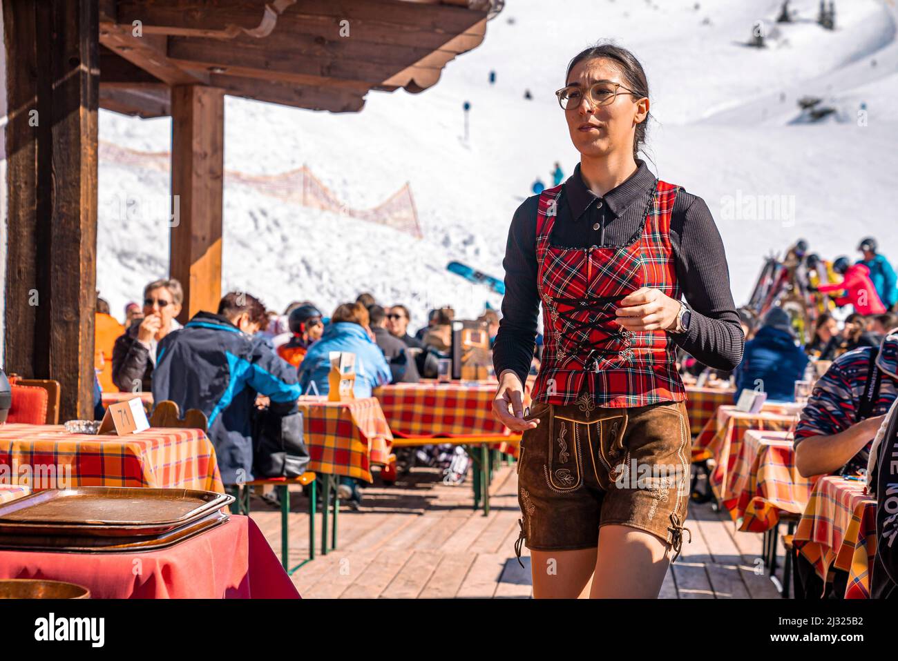 Waitress walking between people sitting on tables at mountain cafe on ...