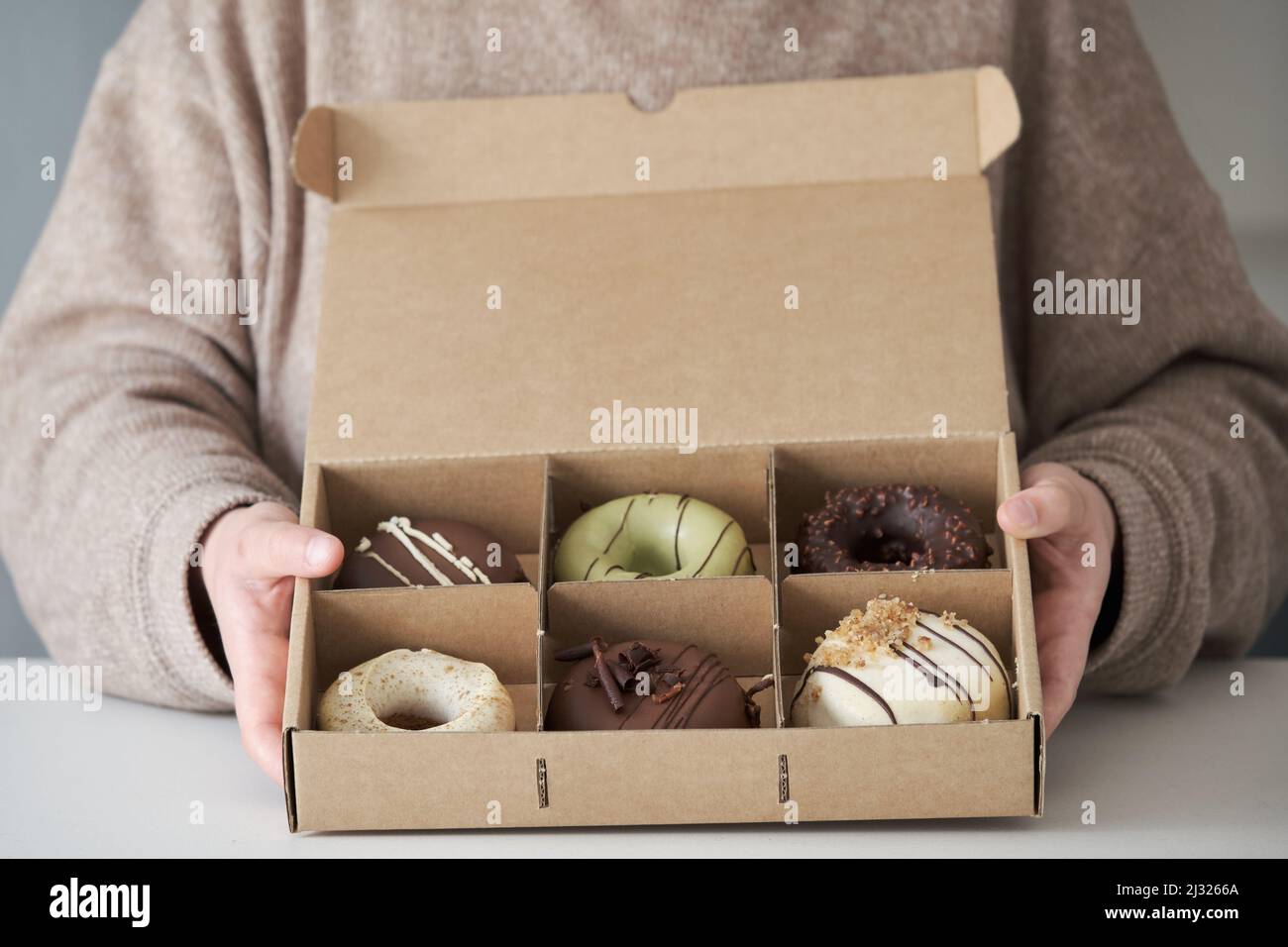 Person holding a choice of various delicious crafted donuts from a ...