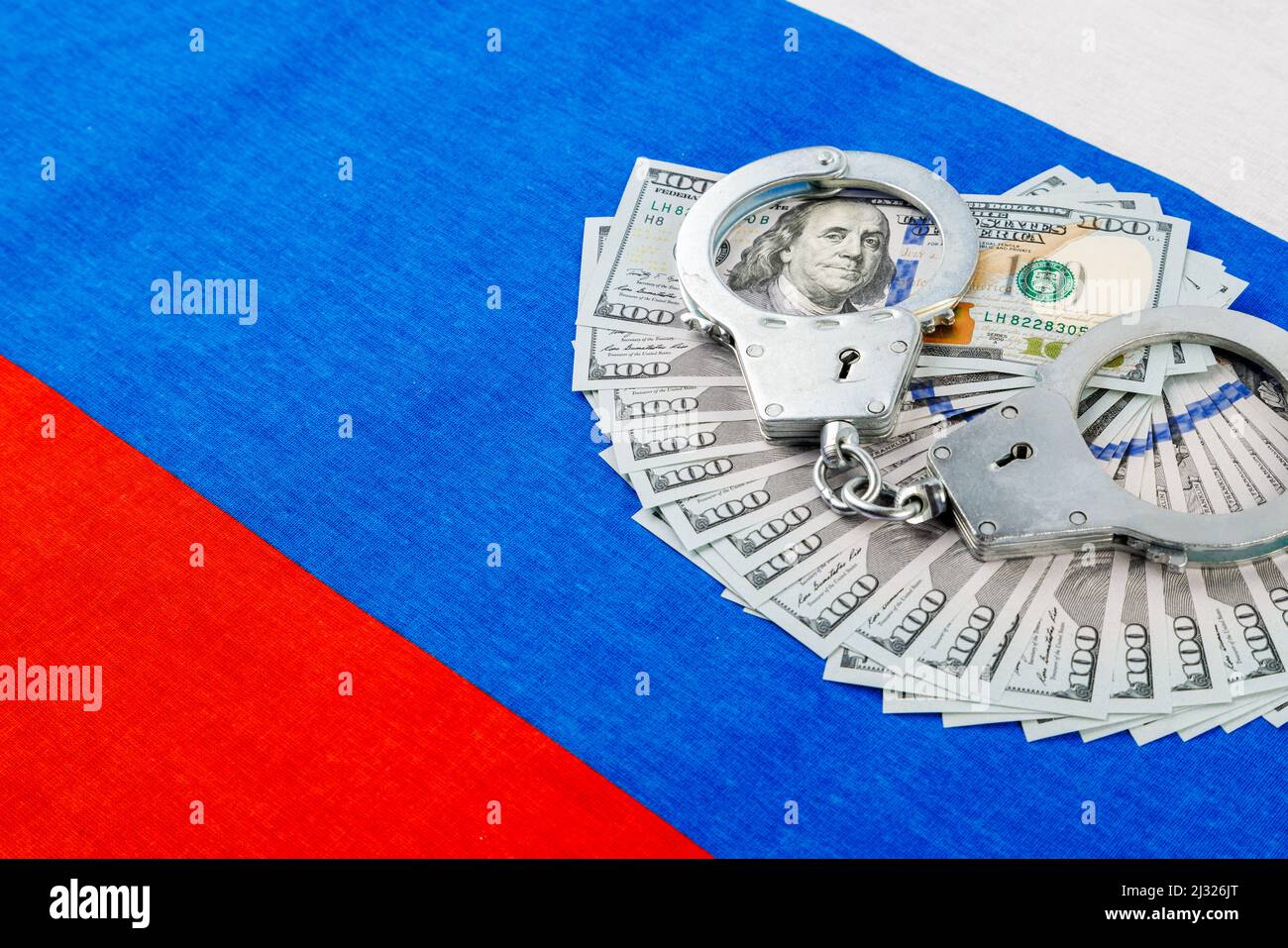 silver metal police handcuffs over paper dollar banknotes of United ...