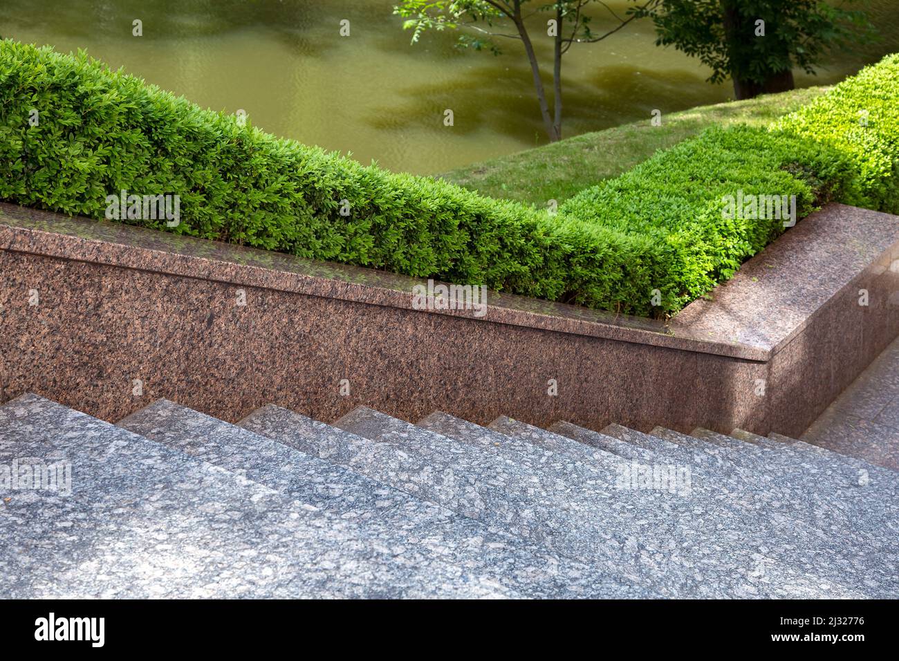granite staircase with stone steps in a park with trimmed boxwood ...