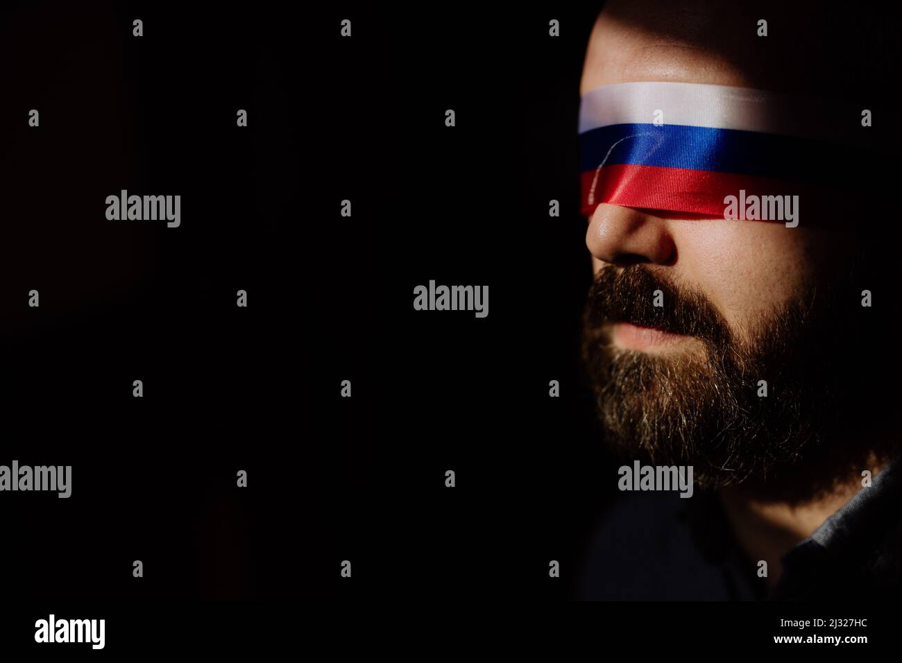 Man with Russian flag blindfold on black background, Russian propaganda ...