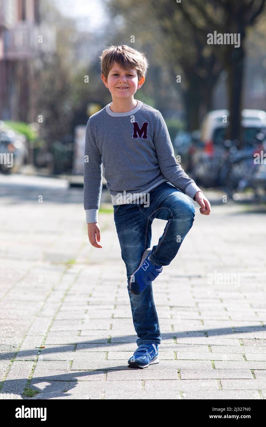 Netherlands, boy is standing on one foot in balance Stock Photo - Alamy