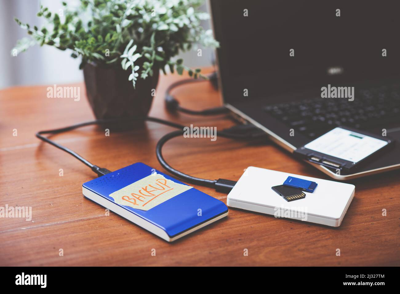 Closeup external hard drive with a tape labeled backup on wooden ...