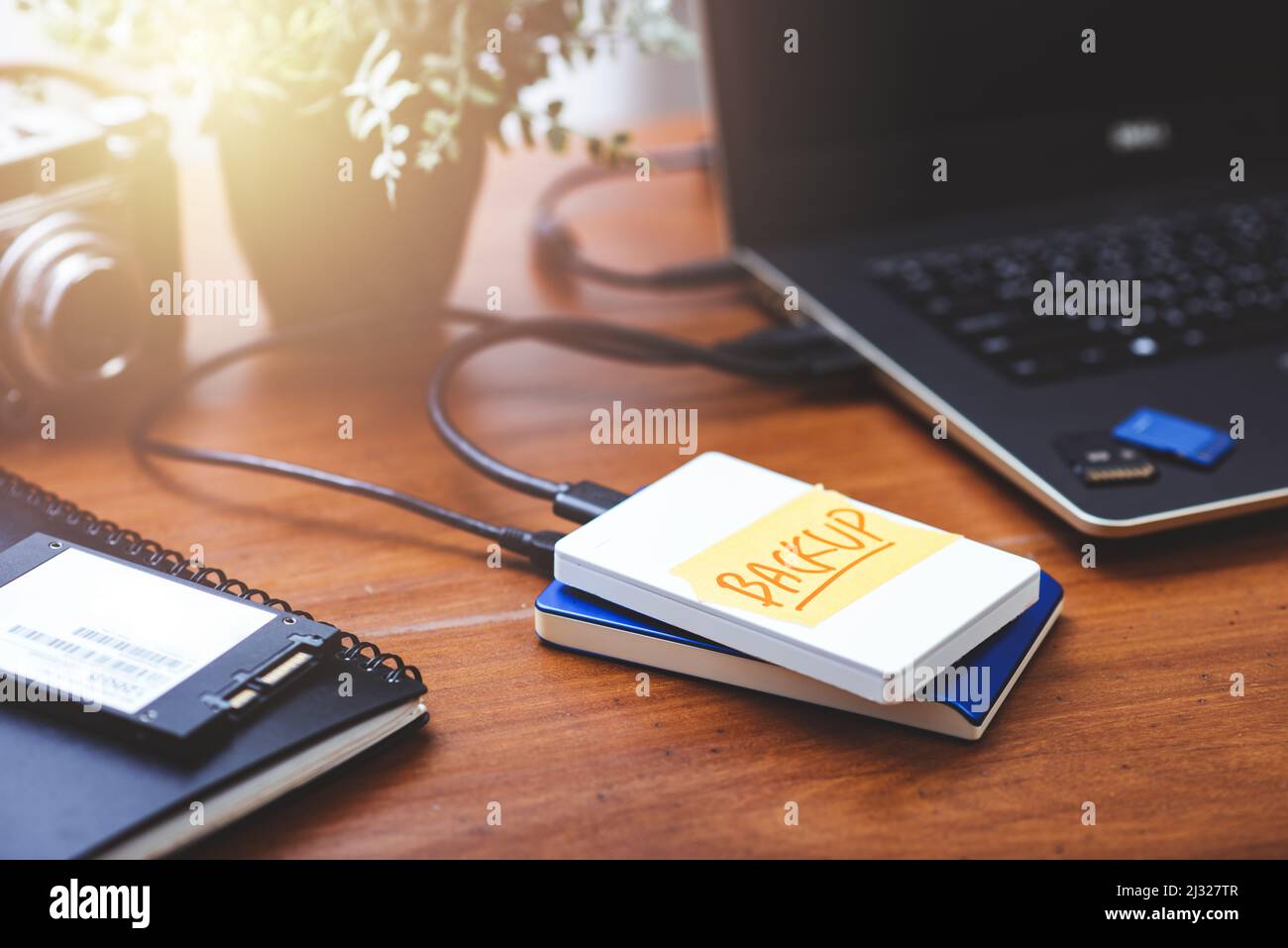 Closeup external hard drive with a tape labeled backup on wooden ...
