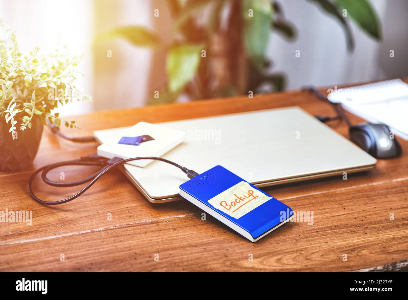 Closeup external hard drive with a tape labeled backup on wooden ...