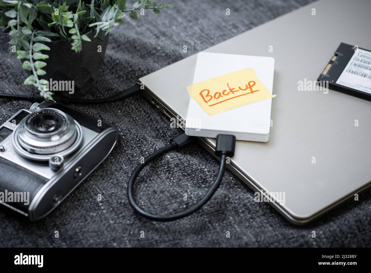 Closeup external hard drive with a tape labeled backup. Working with ...