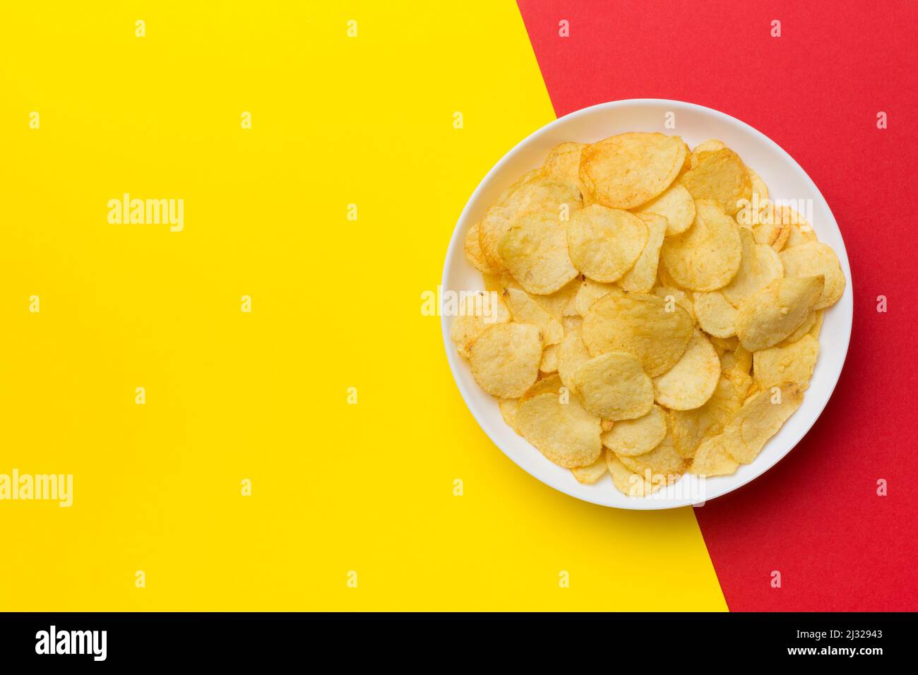 Potato chips on bowl isolated on colored background. Delicious crispy ...