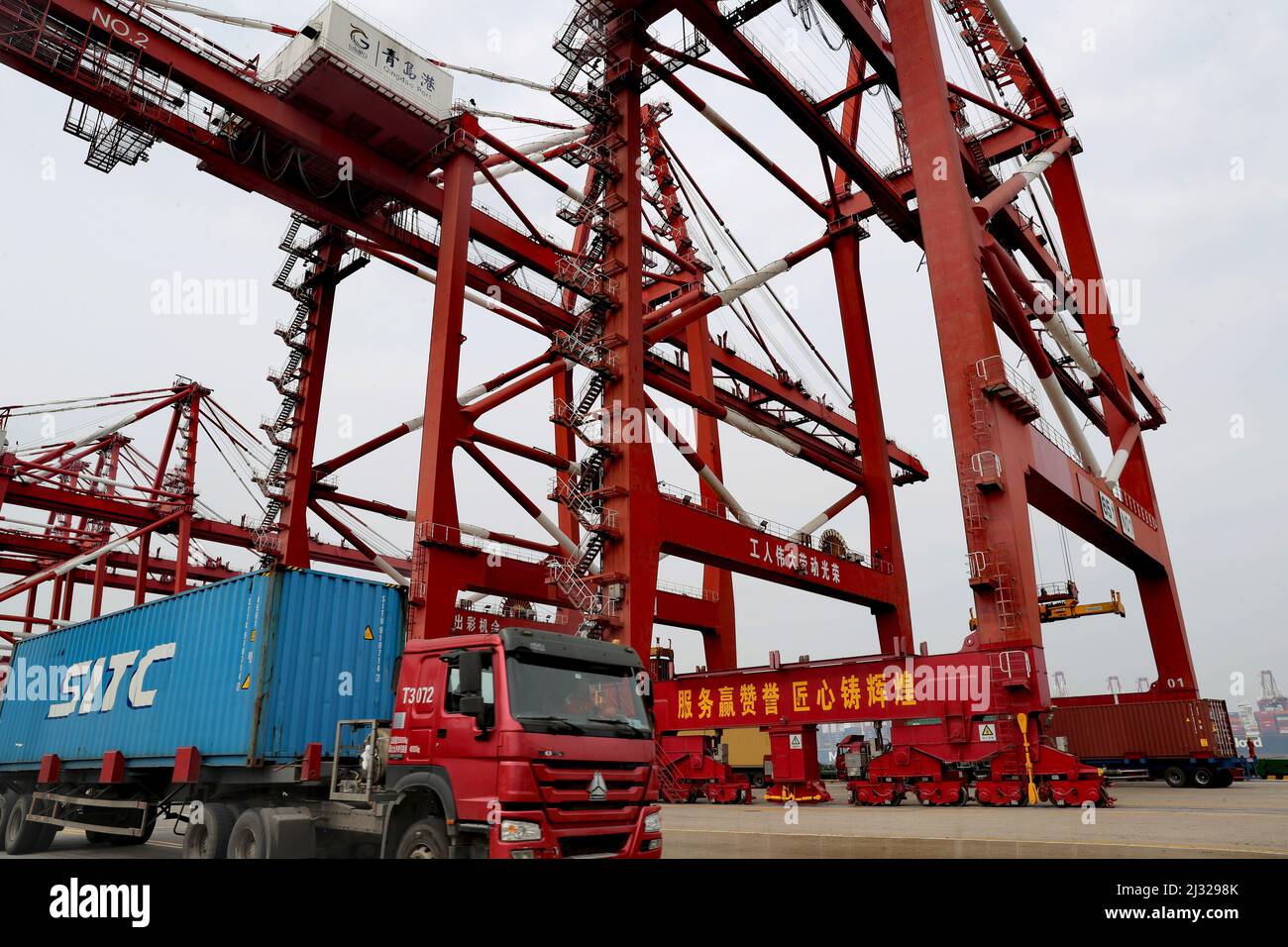 QINGDAO, CHINA - APRIL 5, 2022 - Freighters load and unload goods at ...