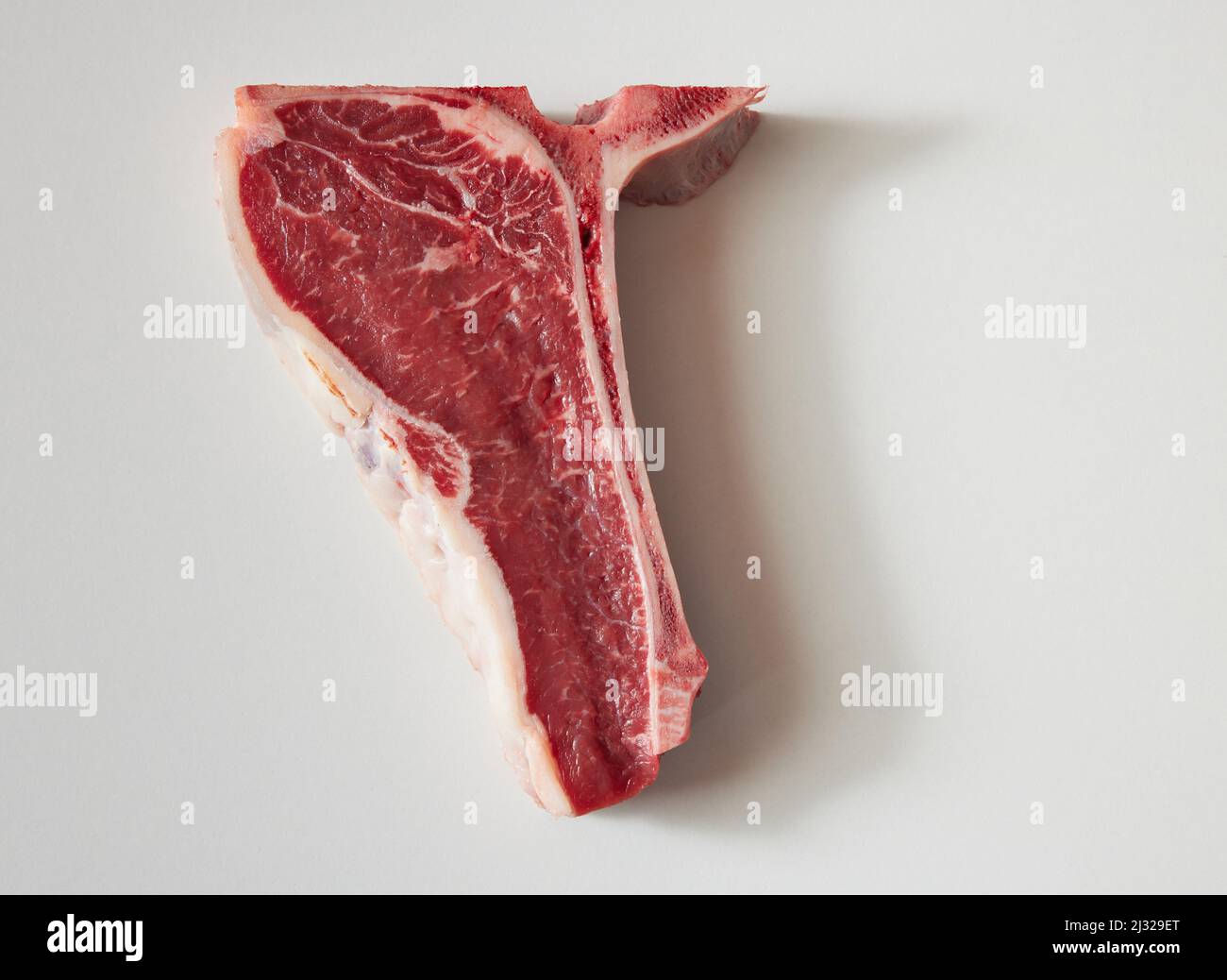 Top down view of a half t-bone steak for diet, eat less meat, safe the ...