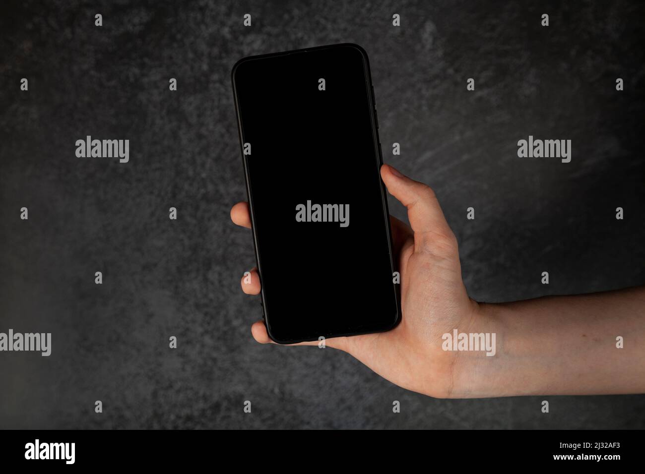 Smartphone in hand. Black screen, copy space, dark background Stock ...