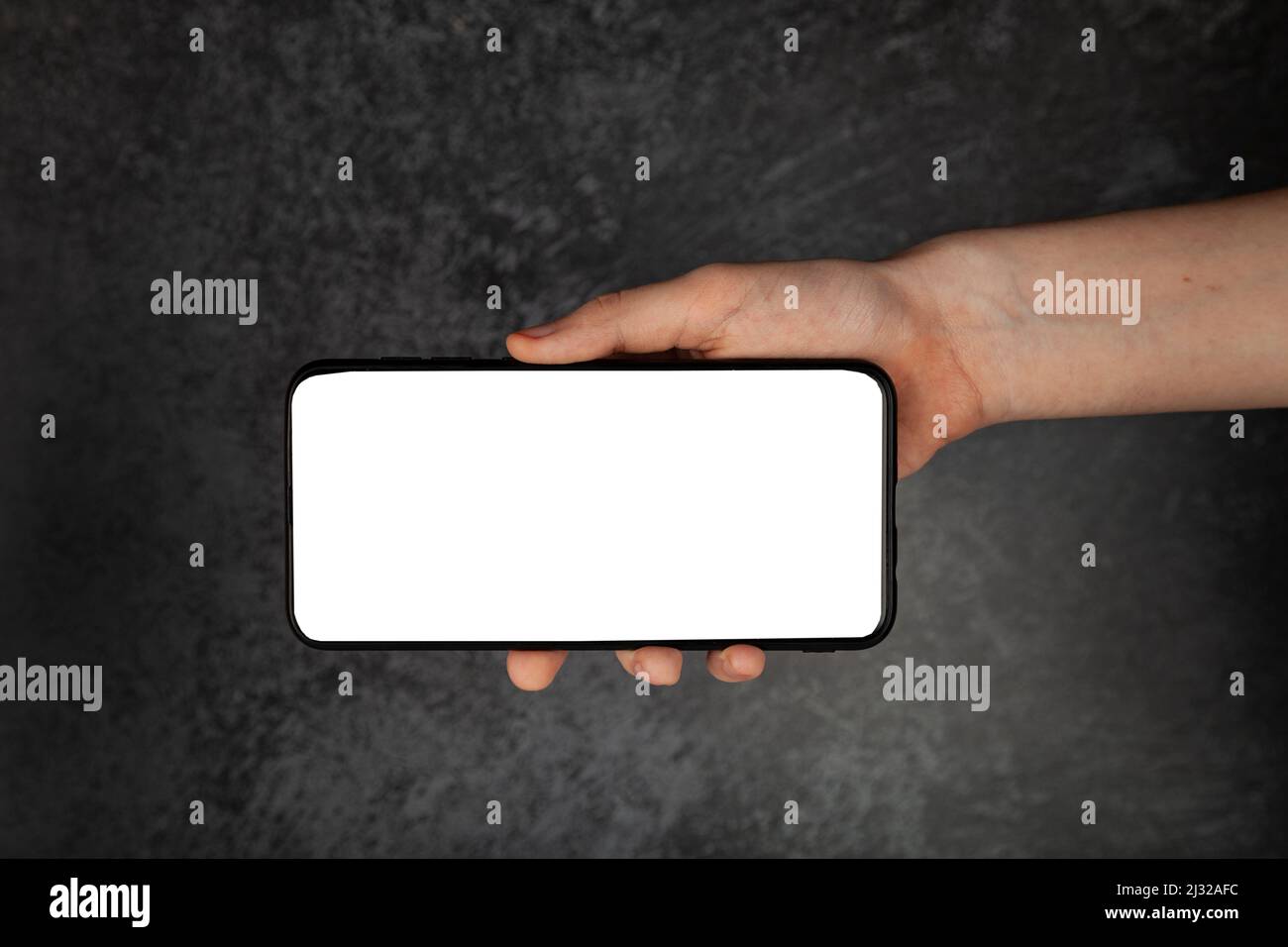 Smartphone in hand. White screen, copy space, dark background Stock ...