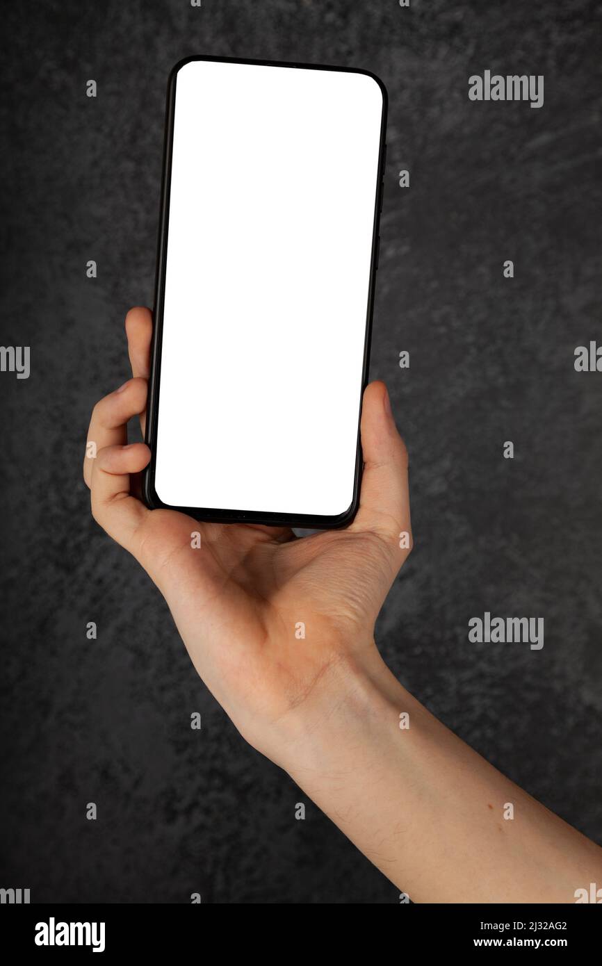 Smartphone in hand. White screen, copy space, dark background Stock ...