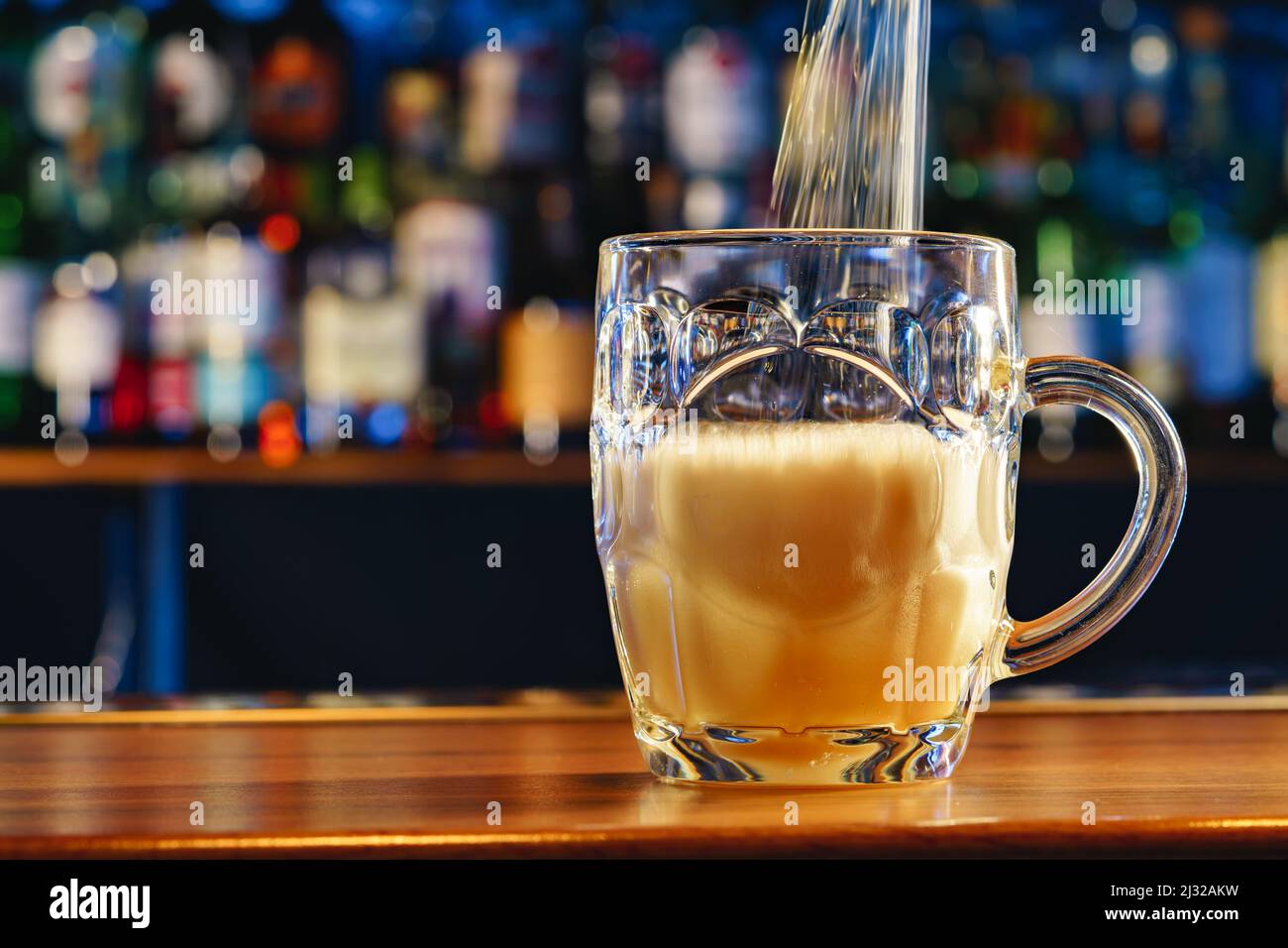 Pouring draft beer into a glass on bar background Stock Photo - Alamy