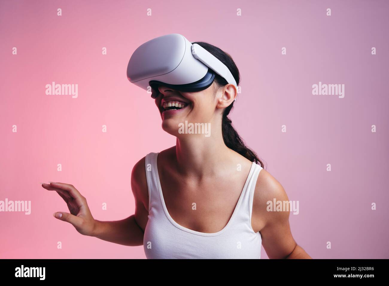 Happy young woman entering a fun virtual reality game in a studio ...