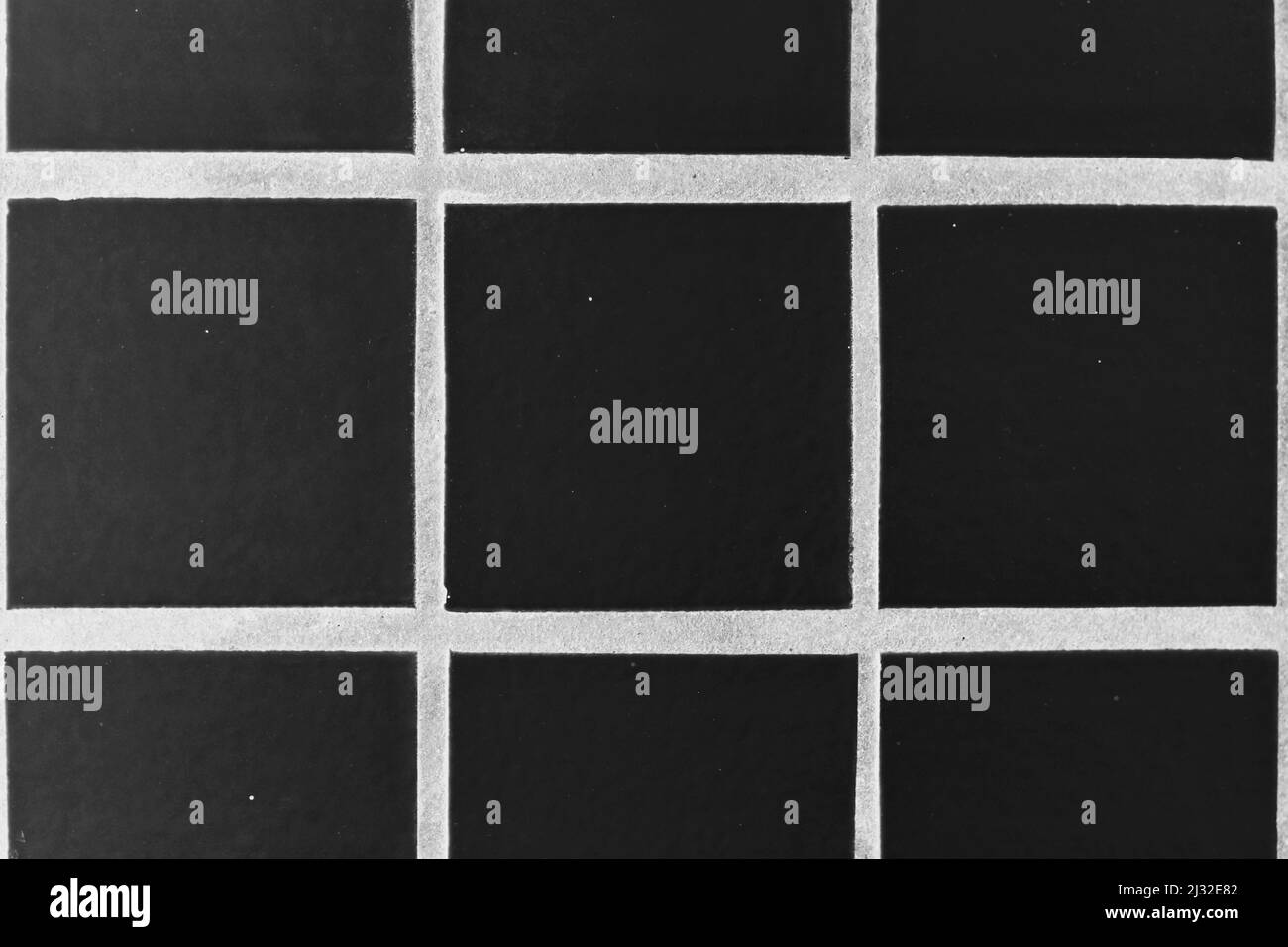 A square tile grid with white perpendicular lines in black and white ...
