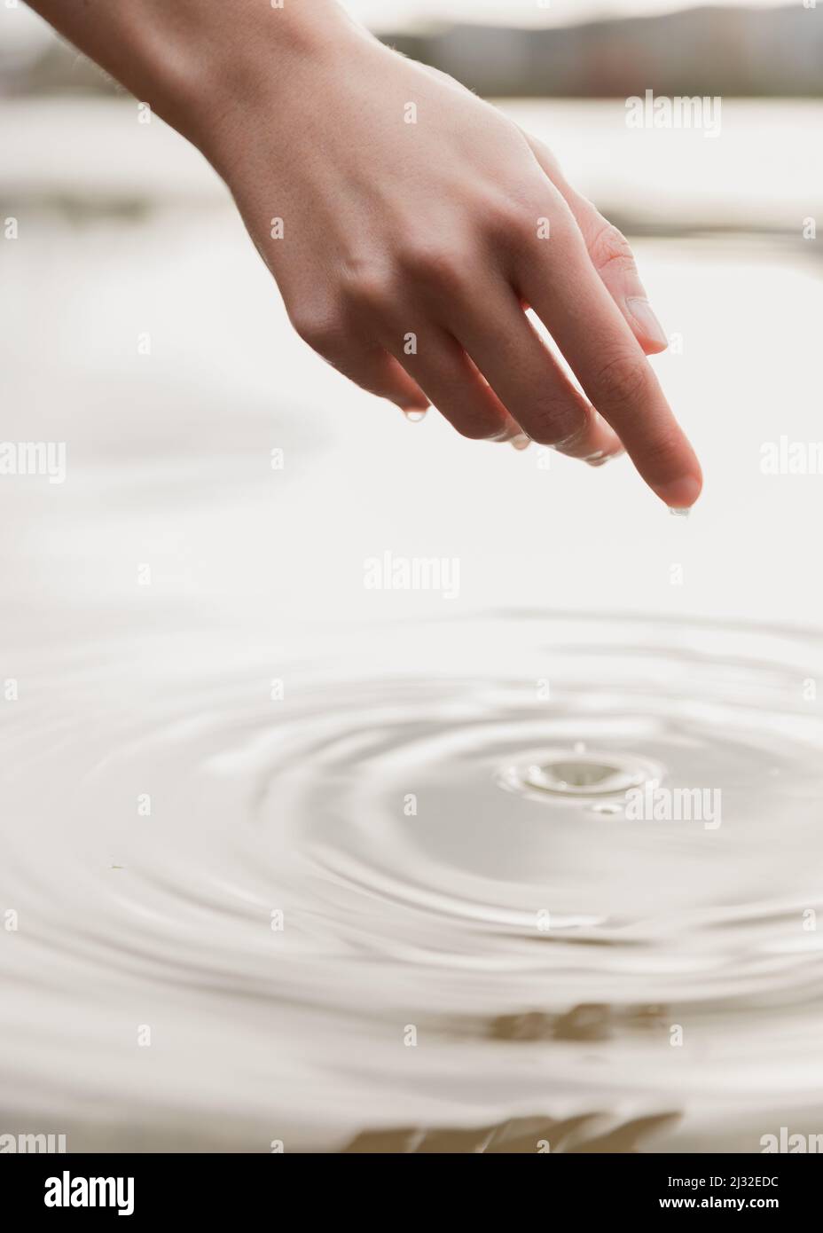 A hand reaches into the water and drips, an image of contemplation ...