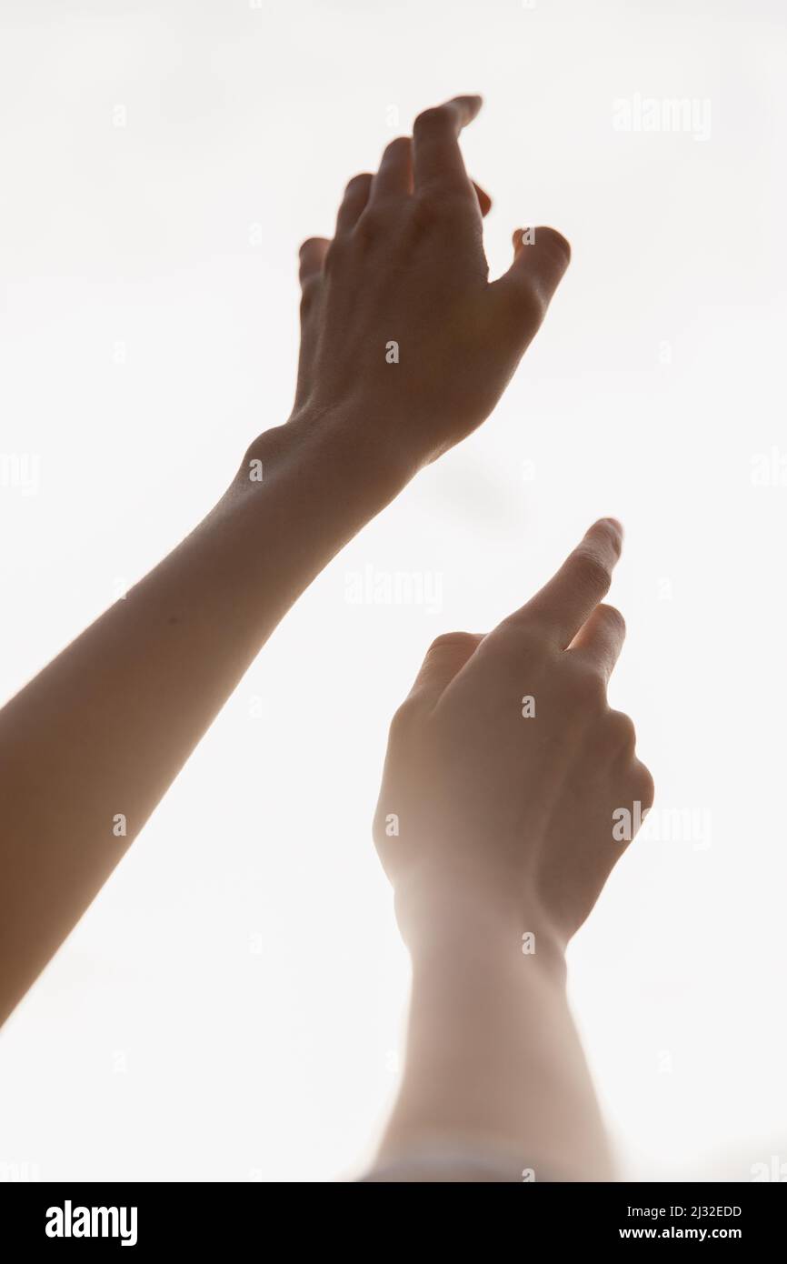 Two hands and arms reach upwards towards the sky, an image of faith ...