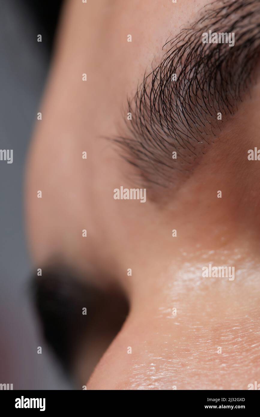 Professional barber doing threading procedure and correcting shape of ...