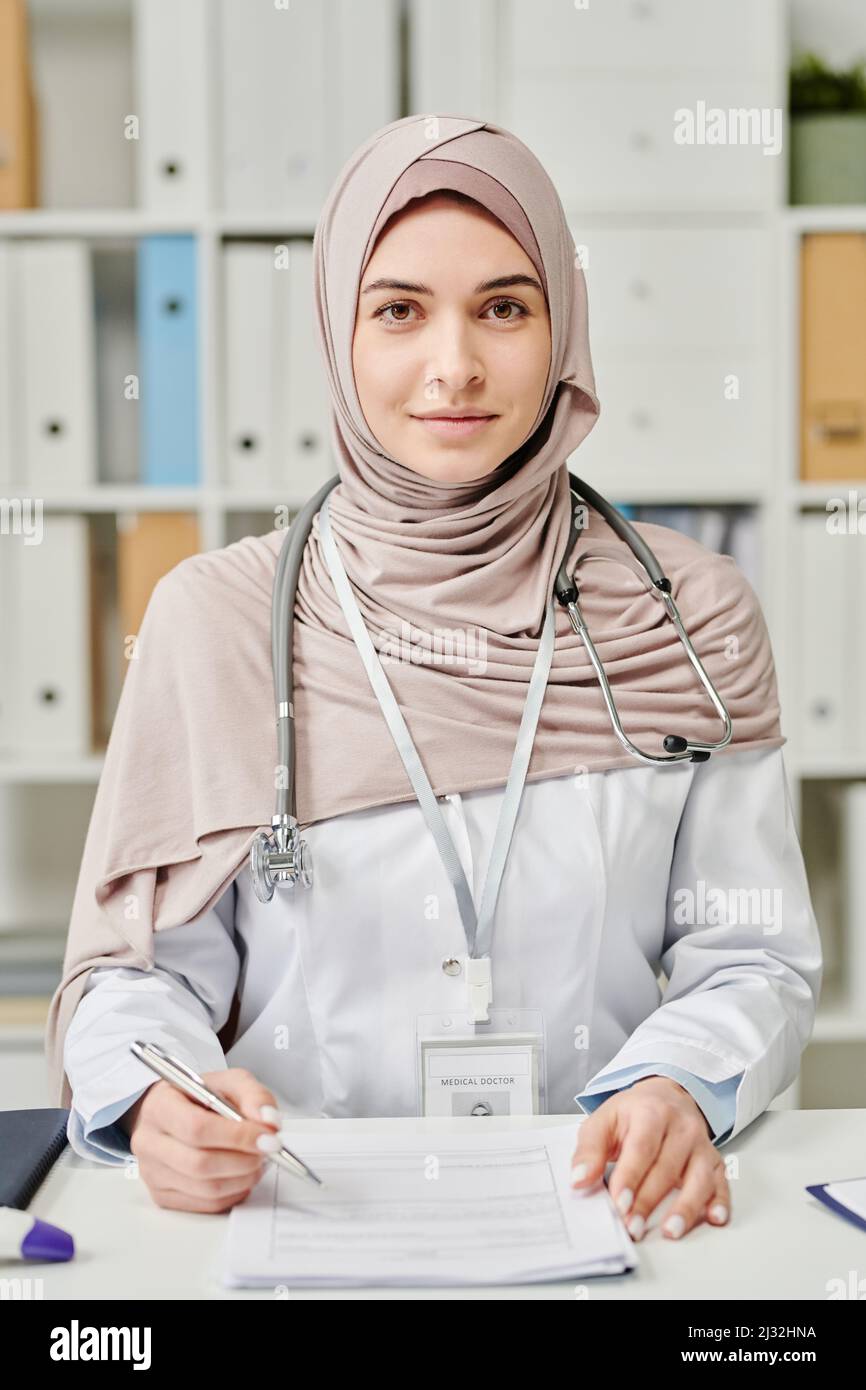 Happy young Muslim female physician or other medical specialist in ...