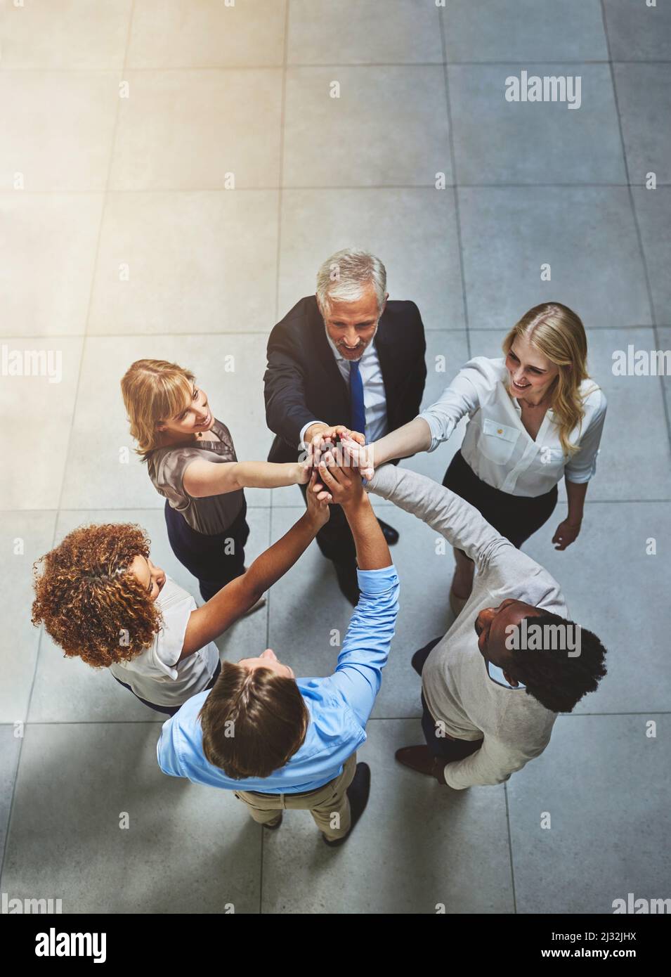 Teamwork always wins. High angle shot of a group of colleagues giving ...