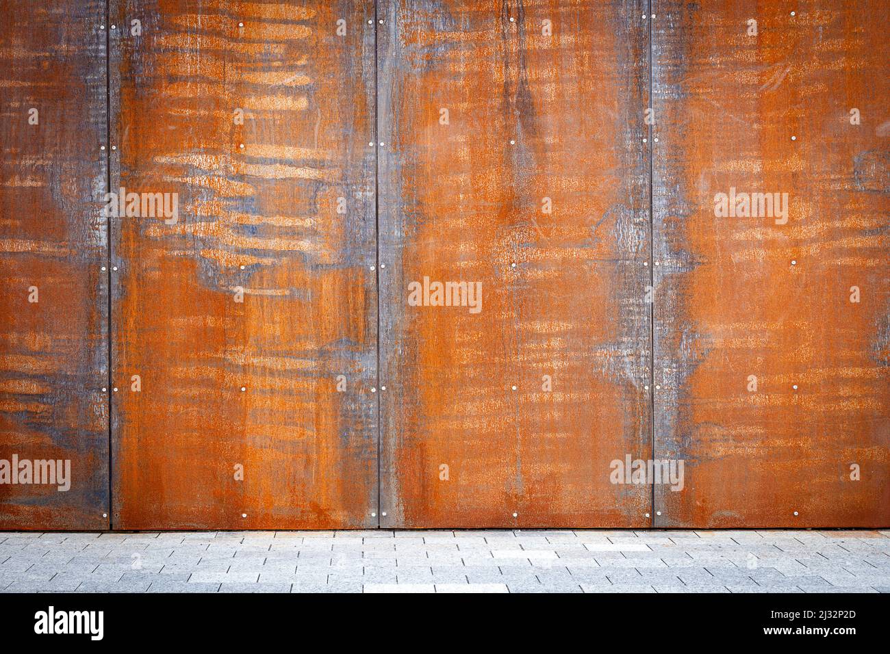 Modern architecture rusty metal wall and a sidewalk Stock Photo - Alamy