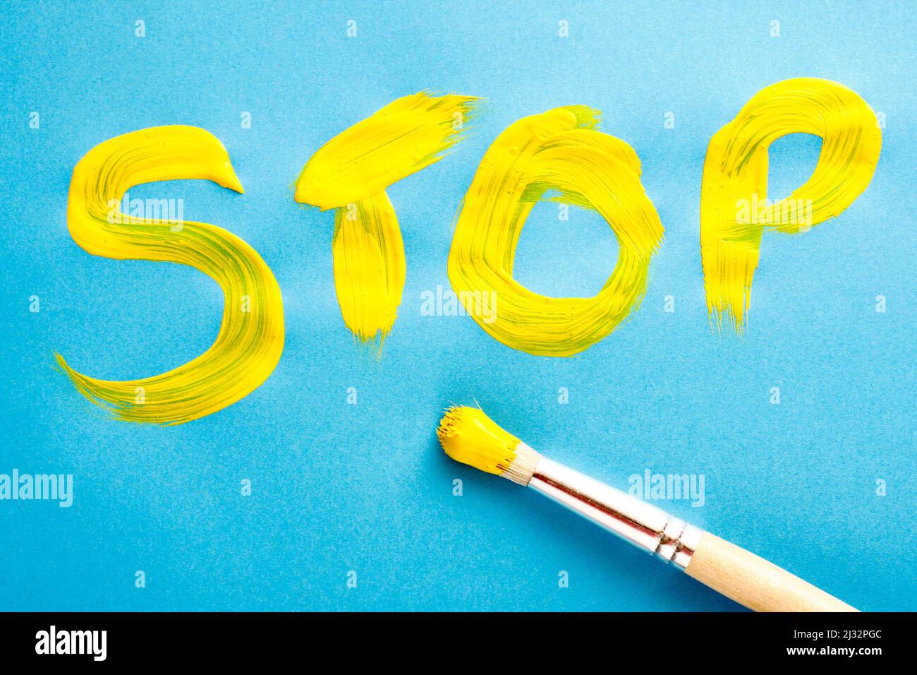 STOP message in yellow and blue color with a paintbrush Stock Photo - Alamy