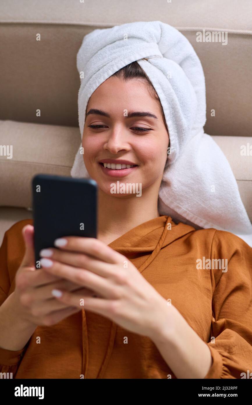 Happy girl in brown blouse and towel on head communicating in video ...
