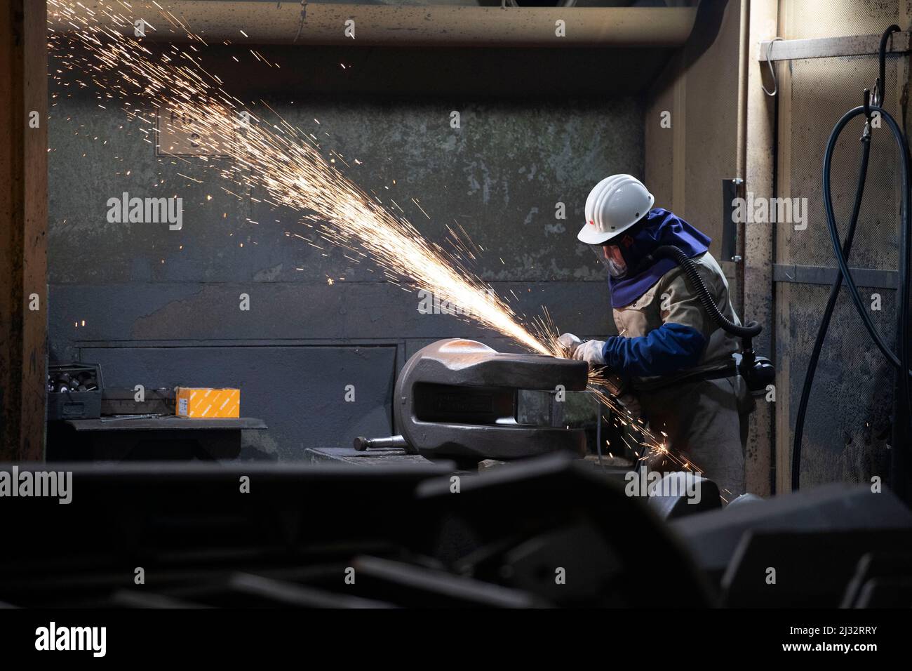 Steel worker deburrs and polishes a cast steel workpiece, Federal Chancellor Olaf Scholz visits ...