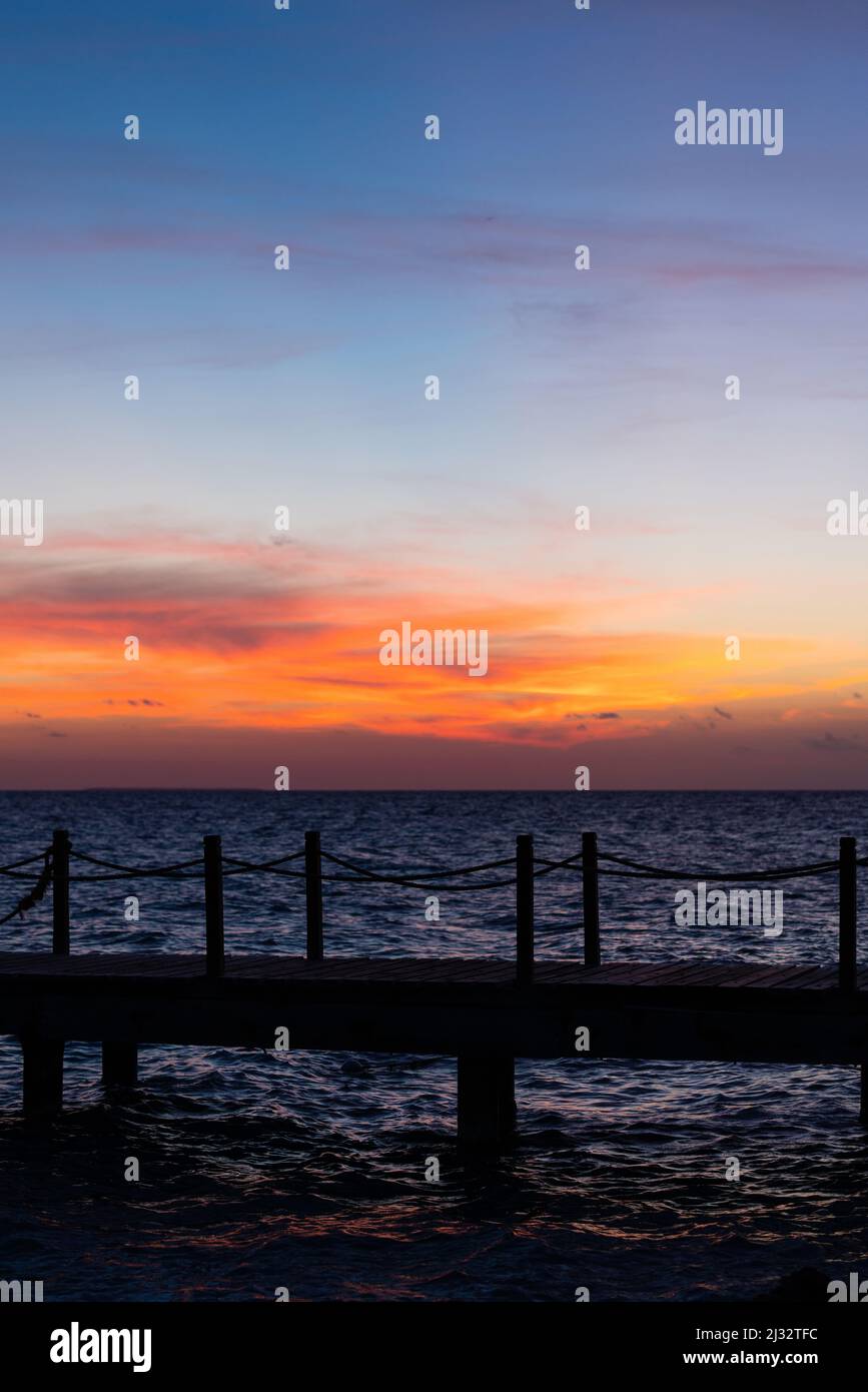 Rope bridge silhouette at sunset. Beautiful seascape, bright orange sky ...