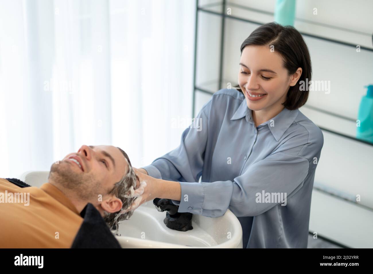 Male customer sitting at the chair in the beauty salon and having his ...