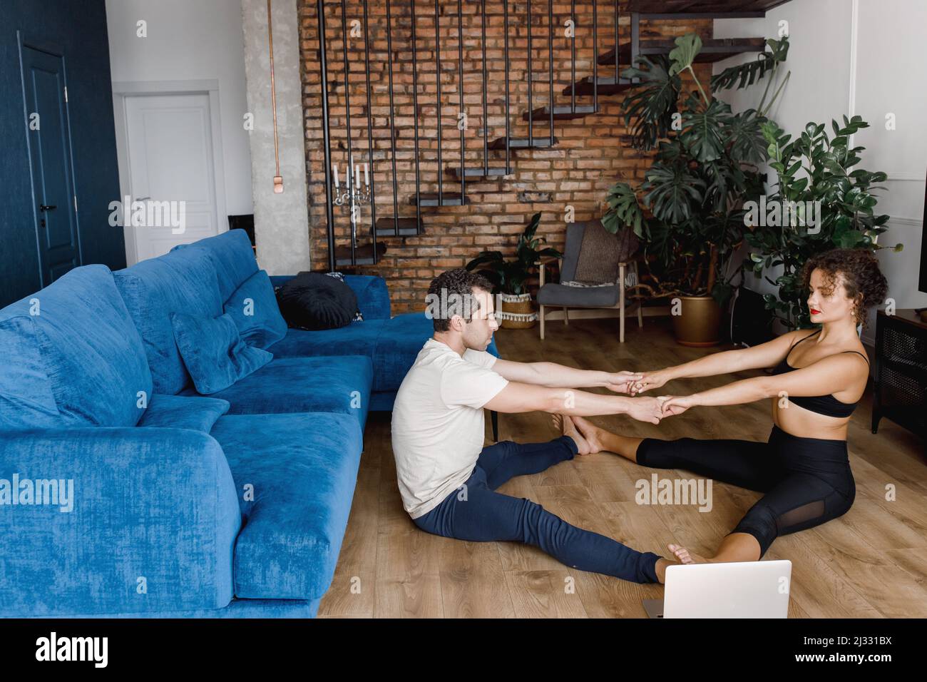 Sporty young couple warming up stretching watching fitness video ...