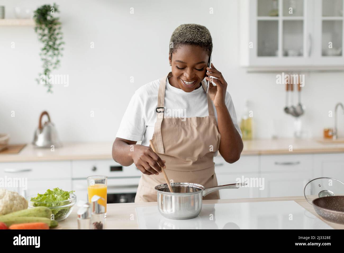 Happy millennial african american woman in apron prepare food and ...
